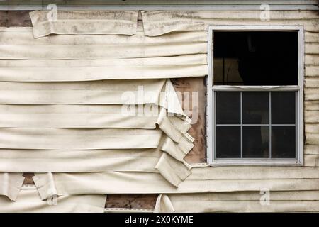 An open exterior window with damaged and melted plastic vinyl siding ...