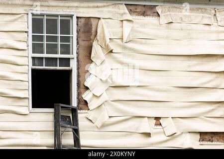 An open exterior window with damaged and melted plastic vinyl siding ...