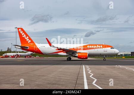 An EasyJet aeroplane in its distinctive white and orange livery taxiing ...