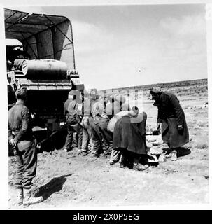 British soldiers with a vehicle stuck in the mud on a road after heavy ...
