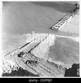A cliff is demolished to connect a breakwater arm as part of port ...