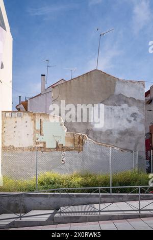 Urban scene with an undeveloped plot of land where the remains of an ...