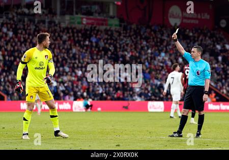 Referee Tony Harrington shows a yellow card to West Ham defender Jean ...