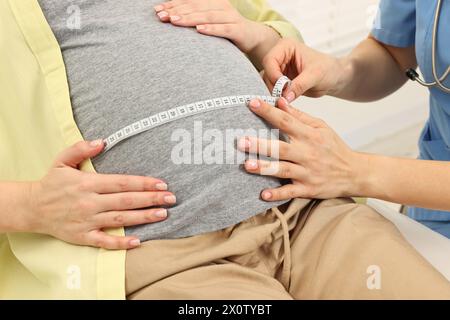 Pregnancy checkup. Doctor measuring patient's tummy in clinic Stock ...