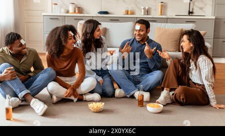 Group of international friends playing guess who game, showing ...
