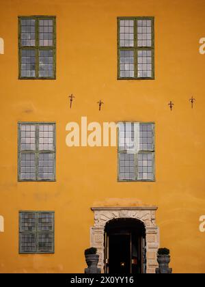 Yellow coloured wall of Wenngarn castle with windows and door, seen ...