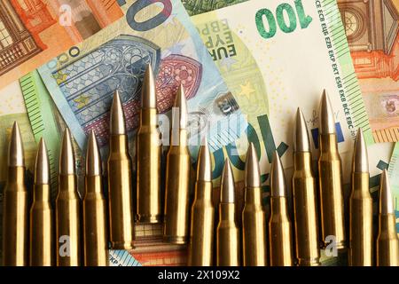 Yellow cartridges and shell casings on euro banknotes. Lot of bills of ...