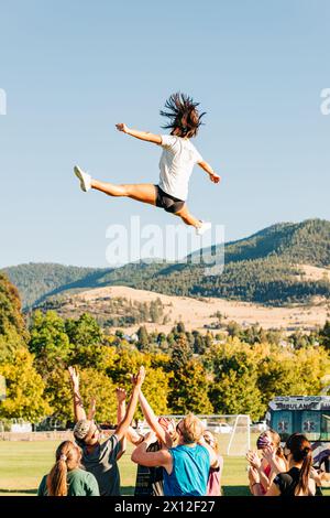 Cheerleader, jump stunt and sports performance on field with teamwork ...