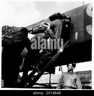 Men wearing dummy parachutes enter a mock fuselage at a Parachute ...