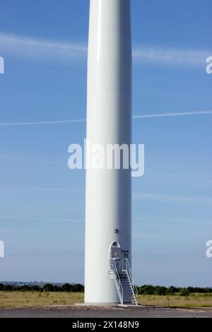 Wind turbine tower and access ladder against blue sky background ...