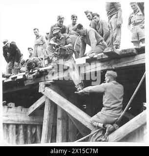 ITALY : EIGHTH ARMY BRIDGE MAKING - Hammering in the spikes which hold ...