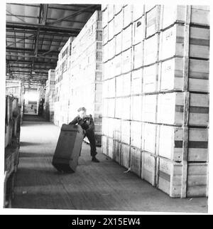 Stacks of British Army packing cases contain rifles, Bren guns, 20mm ...