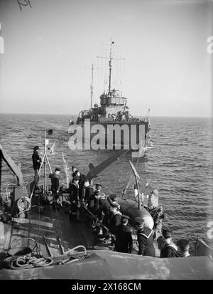 HMS Hebe, a Royal Navy minesweeper, is seen from HMS Rodney ...