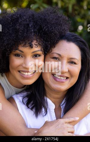 portrait of smiling mother hugging little daughter with beautiful bouquet of flowers, happy ...