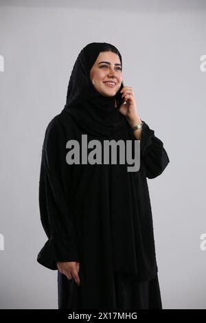 Saudi arabian woman in hijaab standing with mobile in hand Stock Photo ...