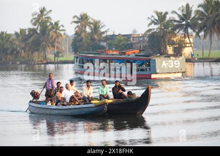 Indian men travelling on a motorboat, canal system of the backwaters ...