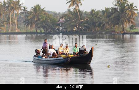 Indian men travelling on a motorboat, canal system of the backwaters ...
