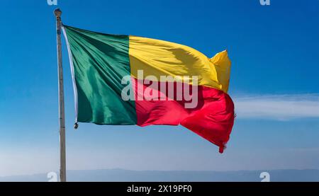 Die Fahne von Benin flattert im Wind, isoliert, gegen den blauen Himmel ...