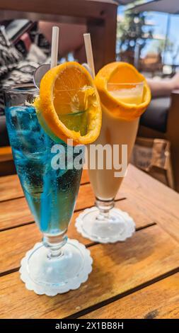 Glasses of cocktails on table on blue sea background Stock Photo - Alamy