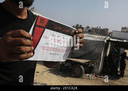 A man reads one of the leaflets dropped by the Israeli army with text ...