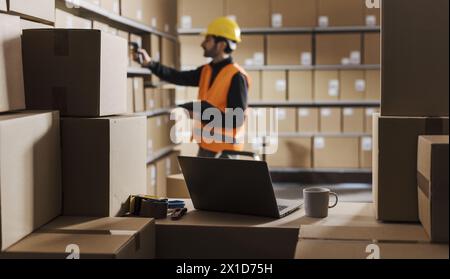 Warehouse clerk scanning labels on packages, delivery and logistics ...