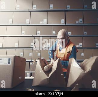 Angry rebellious worker smashing boxes with a bat on the conveyor belt ...