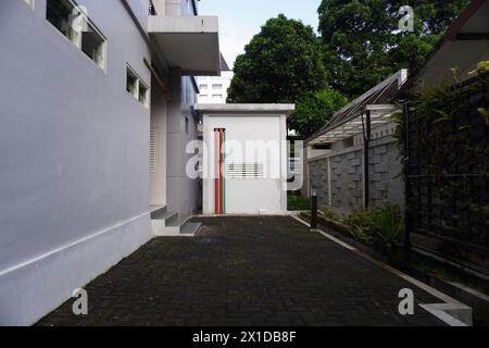 The path beside a minimalist building leads to a small room with ...
