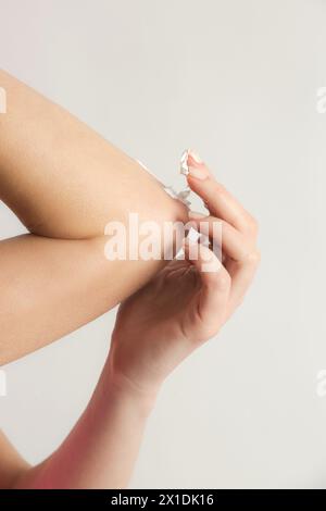 Woman applying elbow cream. Beauty and body care. Winterizing dry itchy ...