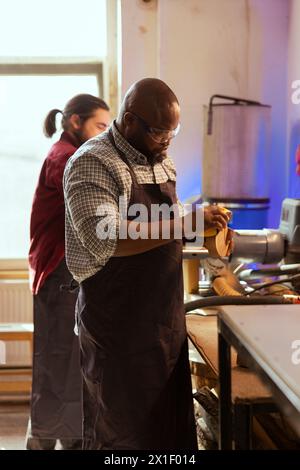 Manufacturer using sandpaper for smoothing wooden surface before ...