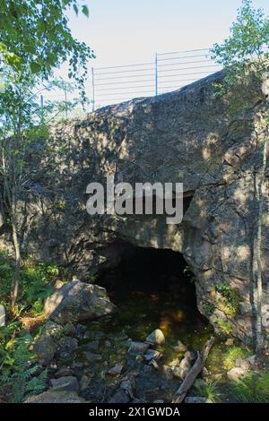 Old cave under cliff that was used as crew shelter and storage area ...