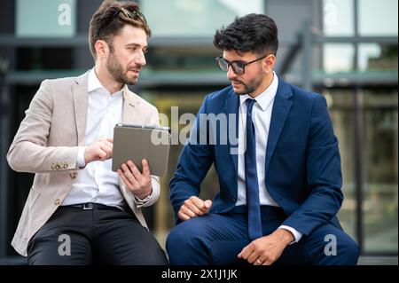 Two Businessman's have a conversation on street bench busy with a ...