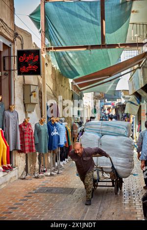 A porter pulls his heavily loaded cart in a street near the Grand ...