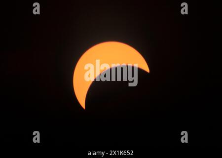 The solar eclipse with a glowing crescent in the dark sky Stock Photo ...
