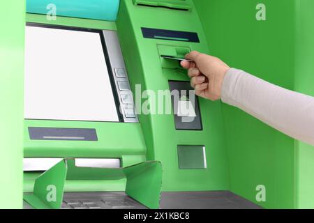 Woman inserting credit card into green cash machine, closeup Stock ...