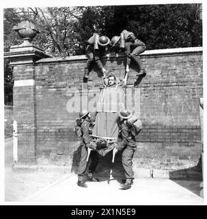 Medical Corps orderlies use commando methods to lift a casualty over a ...
