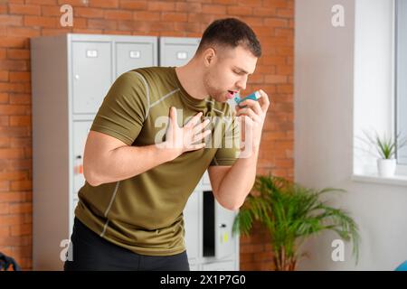Sporty young man using inhaler in gym Stock Photo - Alamy