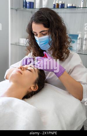 Cosmetologist making the rejuvenating facial injections procedure for ...