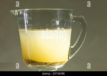 Sand in a jug of water with the coarse particles settled on the bottom ...