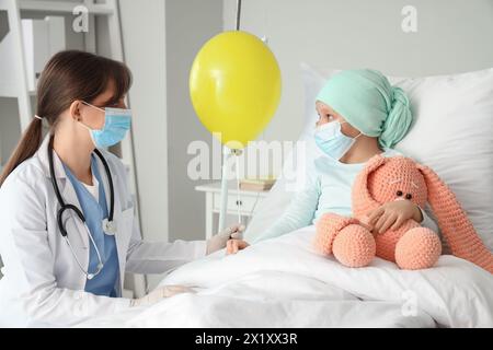 Little girl after chemotherapy receiving blue balloon from doctor in ...