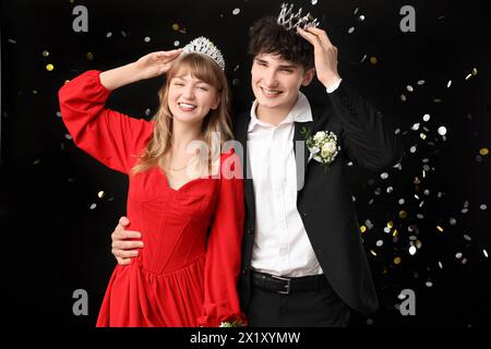 Happy prom couple with crowns and confetti on black background Stock ...