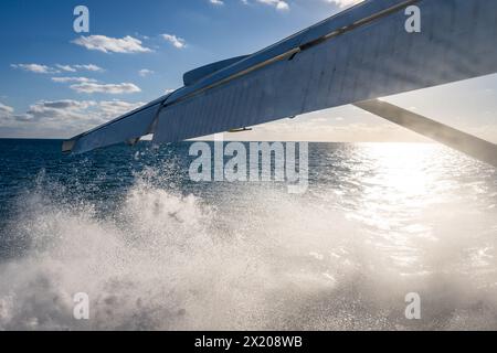 Swirling mist and water droplets caused by seaplane taking off from the ...