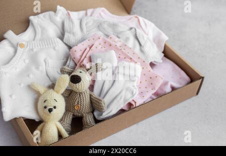 Baby and child clothes and knitted toys in carton box. Donation ...