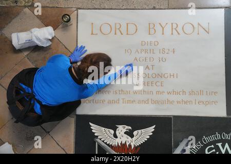 Conservator Lucy Ackland cleans Lord Byron's memorial stone in Poets' Corner at Westminster ...