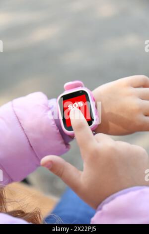 Little girl using SOS function on smartwatch outdoors, closeup Stock ...
