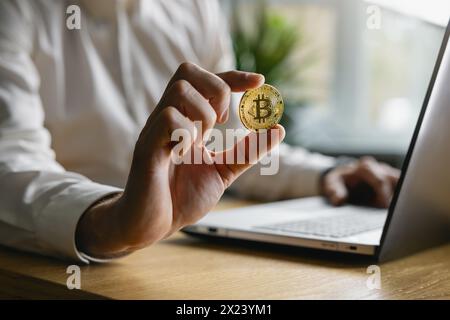 Closeup of hand holding golden bitcoin, advertising coin, copy space ...