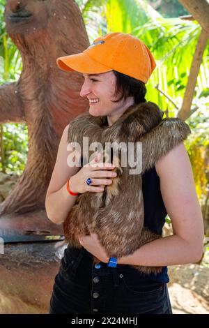 An adult woman holds a three-toed sloth (Bradypus variegatus) at Jungle ...