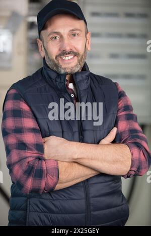 Mechanic man with beard wearing blue uniform and safety glasses over ...
