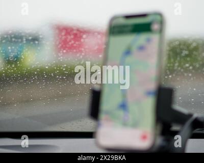5g Smartphone displaying GPS navigation mounted on a car's dashboard, A1 A8 near Milan, Italy ...