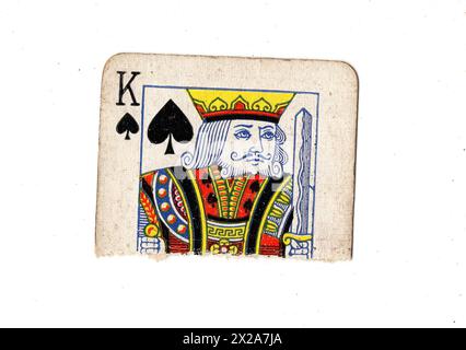 A vintage, well used king of spades playing card torn in half on a ...