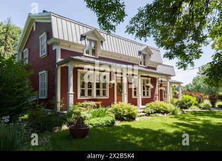 Old 1892 burgundy with white trim pinewood plank house facade with ...